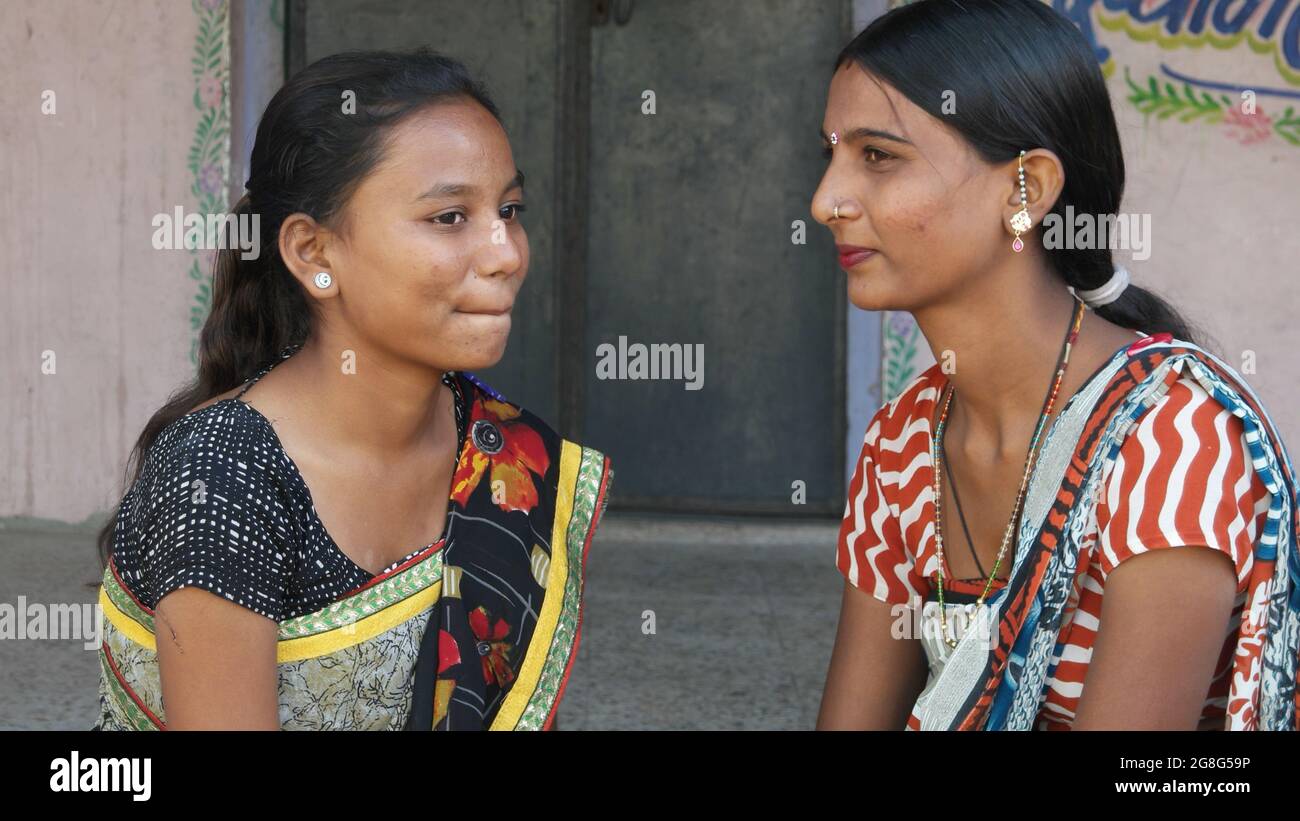 Closeup of two beautiful Indian women in traditional clothing talking ...