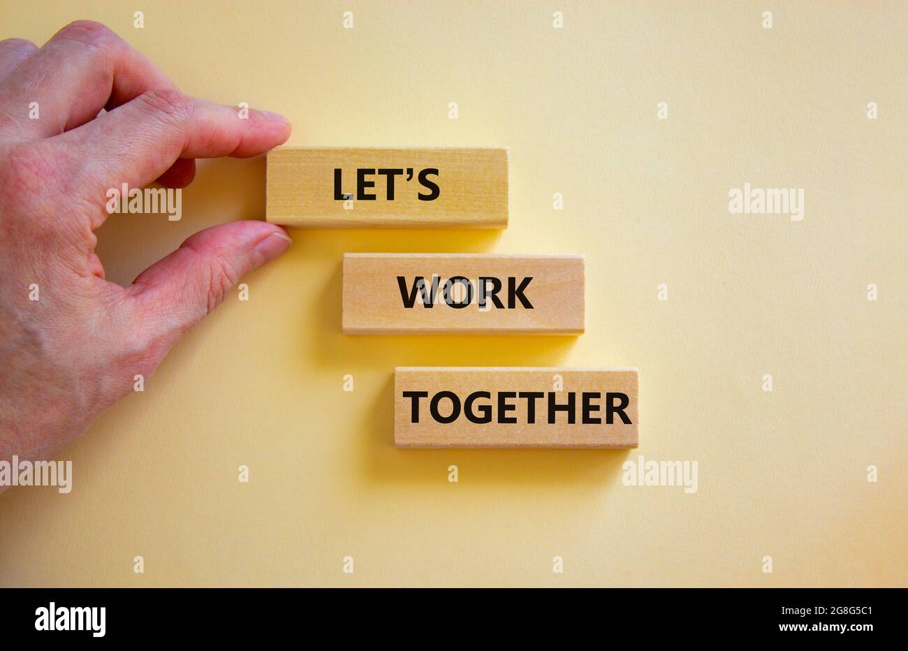 Work together symbol. Wooden blocks with words Let is work together on ...