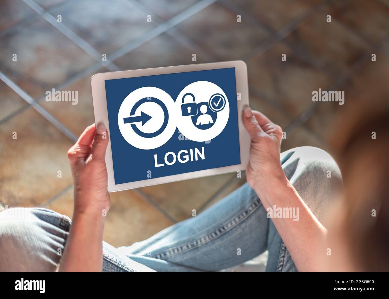 Woman sitting on the floor with a tablet showing login concept Stock ...