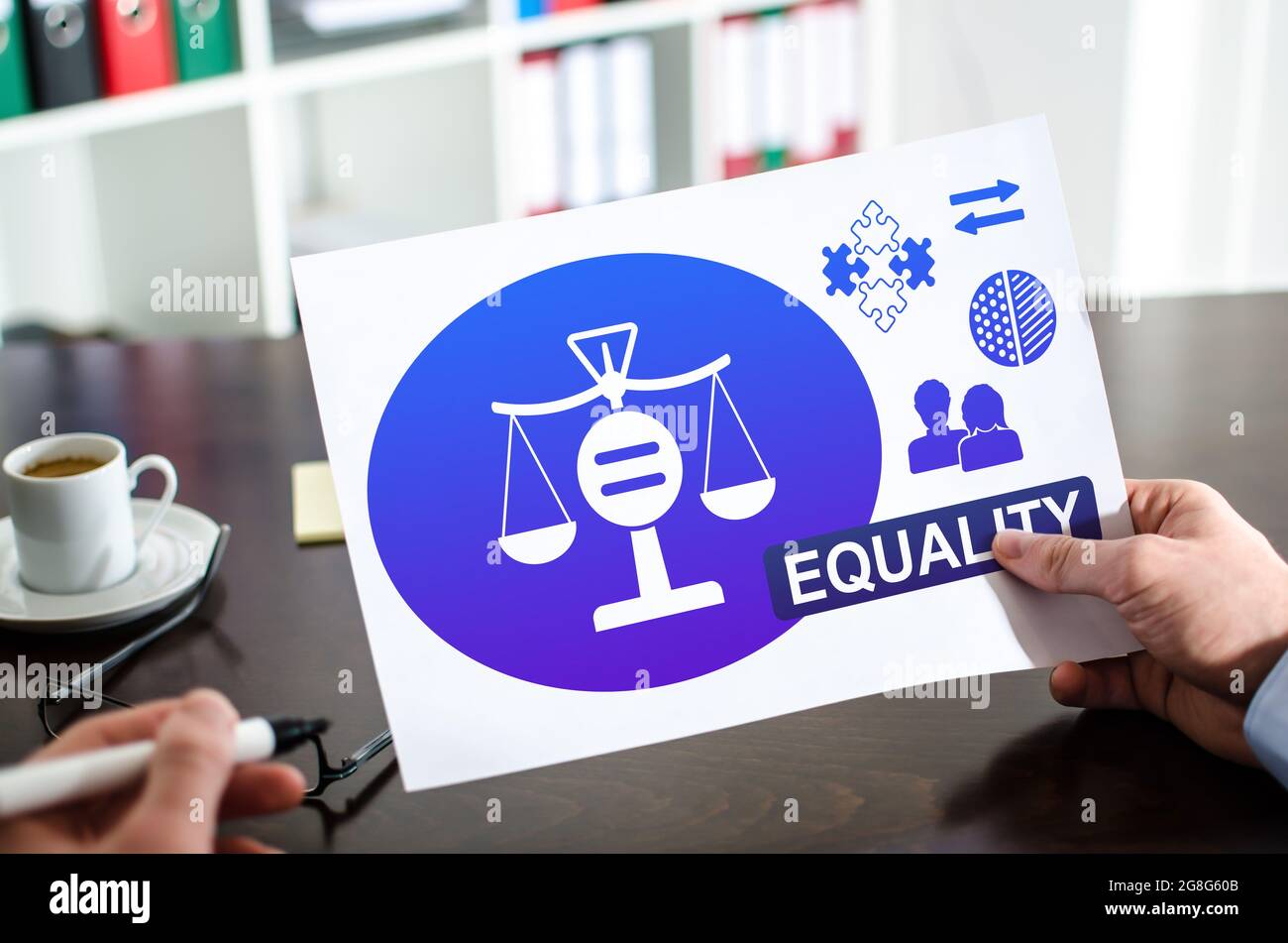 Hand holding a paper showing equality concept Stock Photo - Alamy