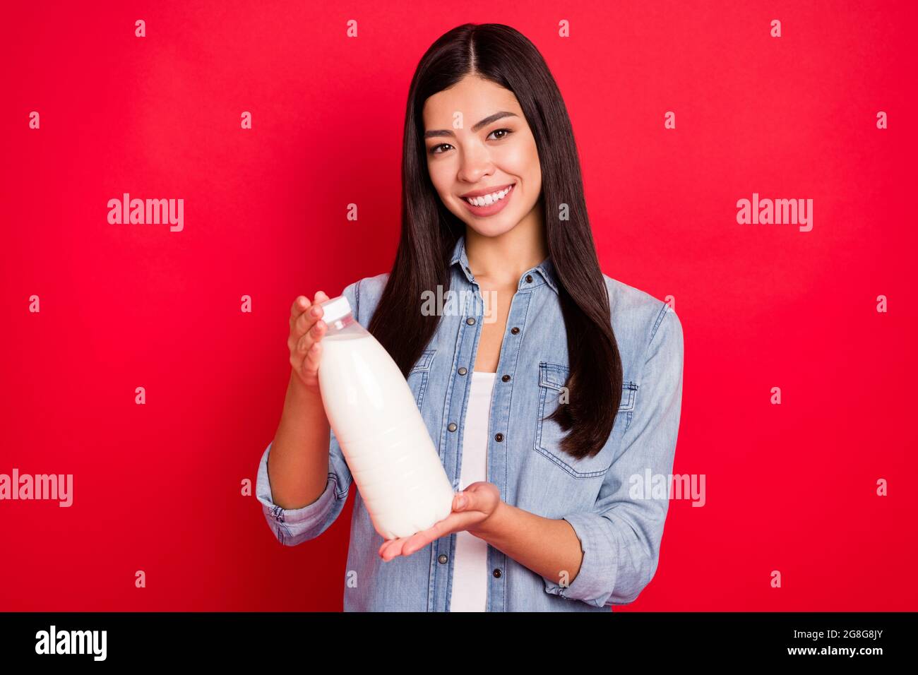 Portrait of attractive cheerful girl holding in hands fresh bio milk ...