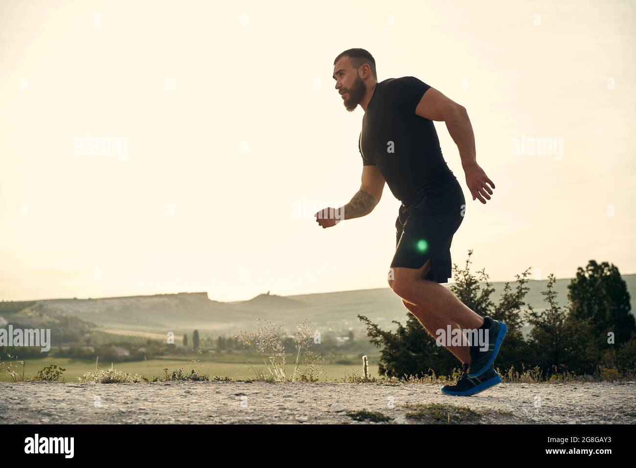 Young muscular male athlete running up the hill Stock Photo - Alamy