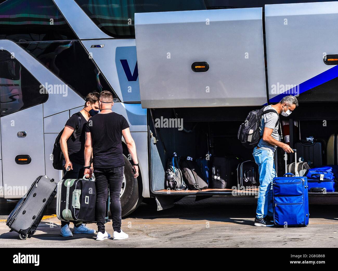 Passengers load their luggage into a bus at the central intercity bus ...