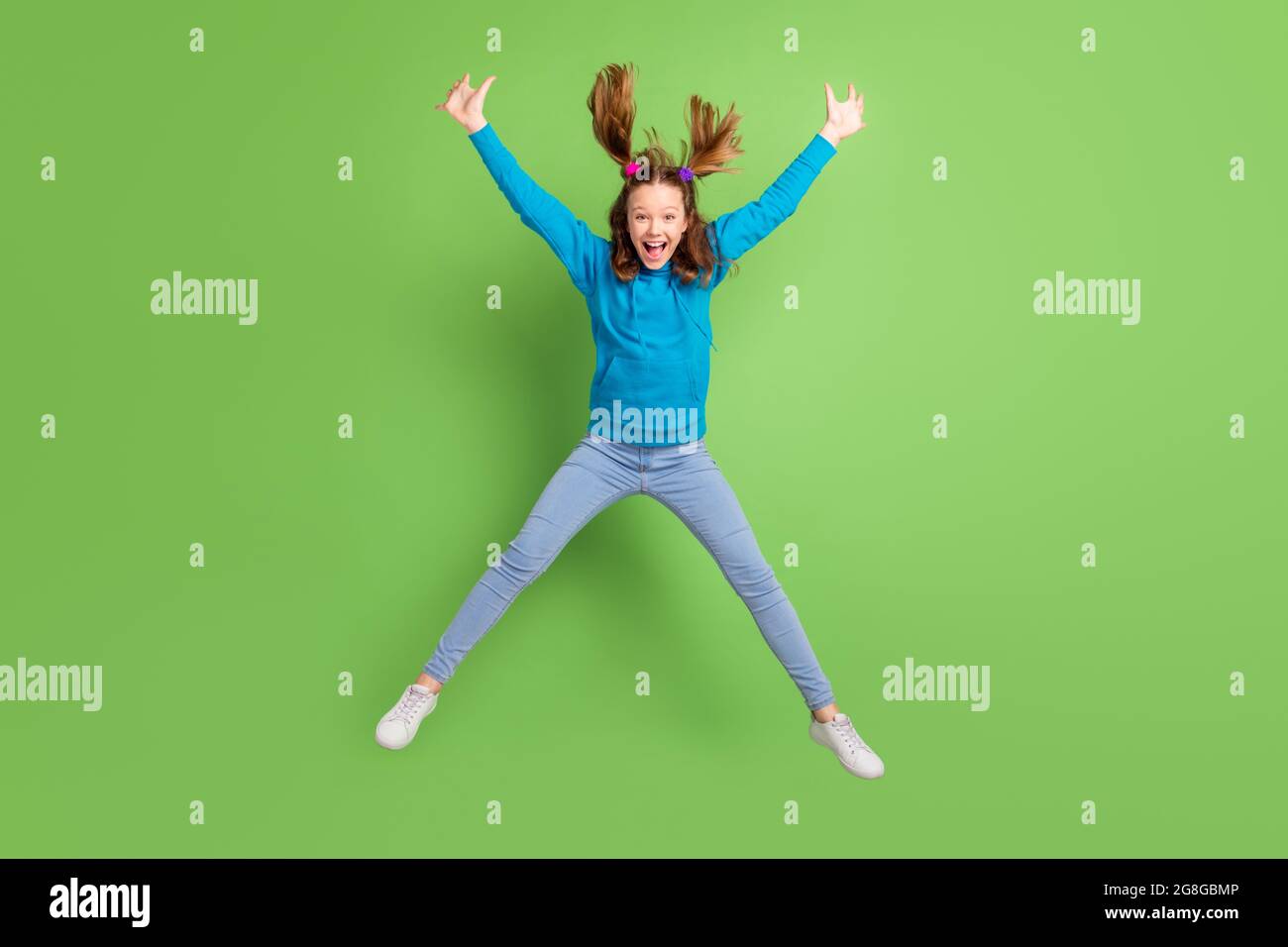 Full length photo of crazy happy girl jump up raise hands fly hair ...