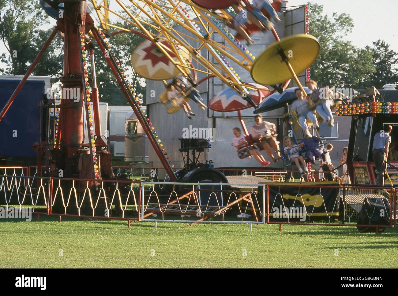 1990s, historical, people sitting on a swing ride or chair swing ...