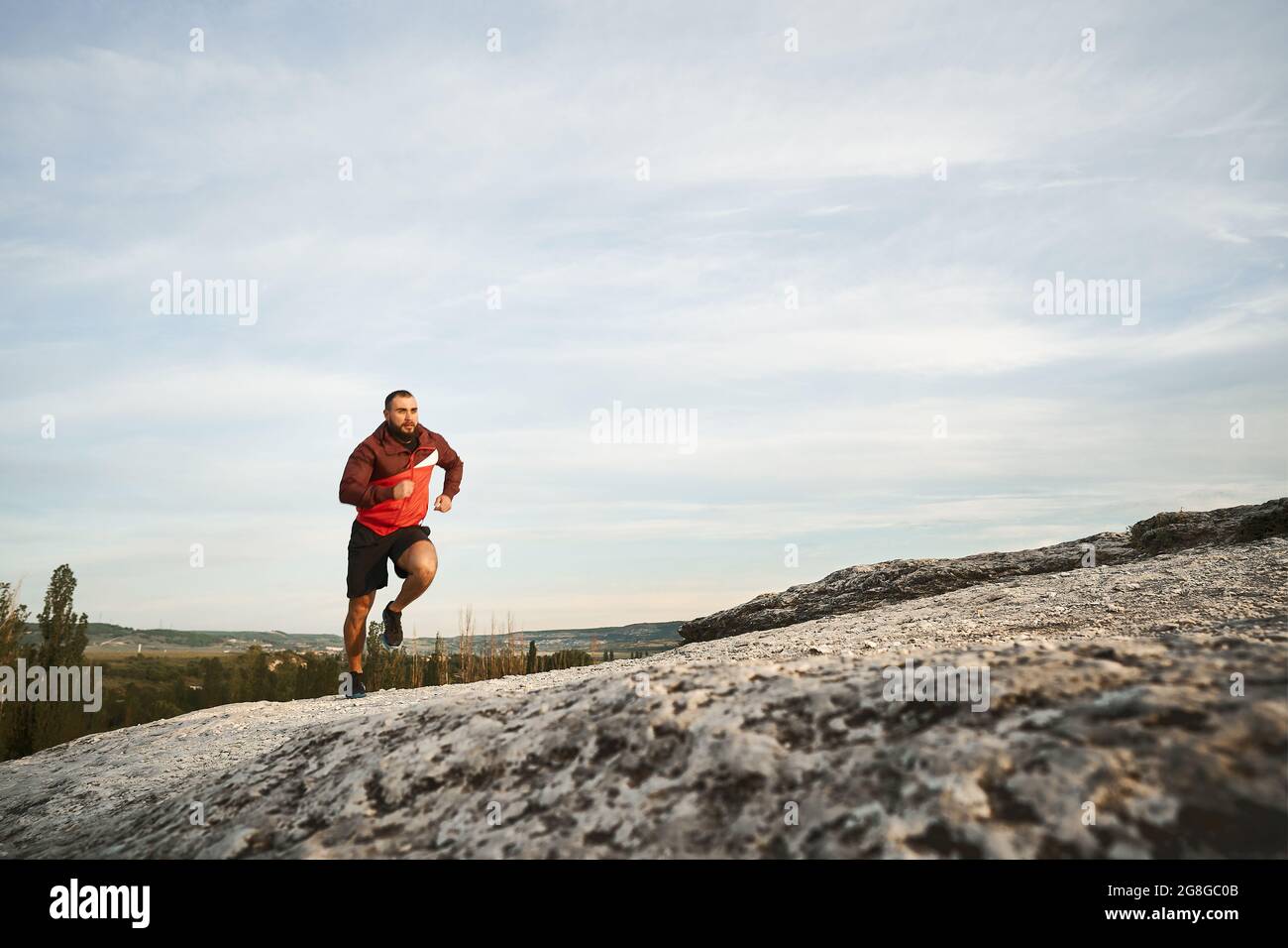 Young muscular male athlete running up the hill Stock Photo - Alamy