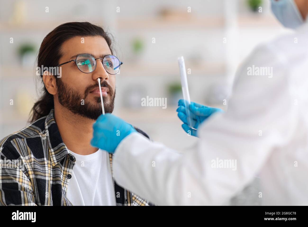 Arab man getting nasal coronavirus swab test at home Stock Photo - Alamy