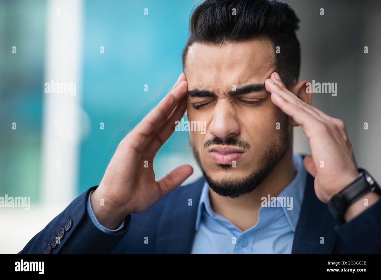 Stressed young arab businessman suffering from headache Stock Photo - Alamy