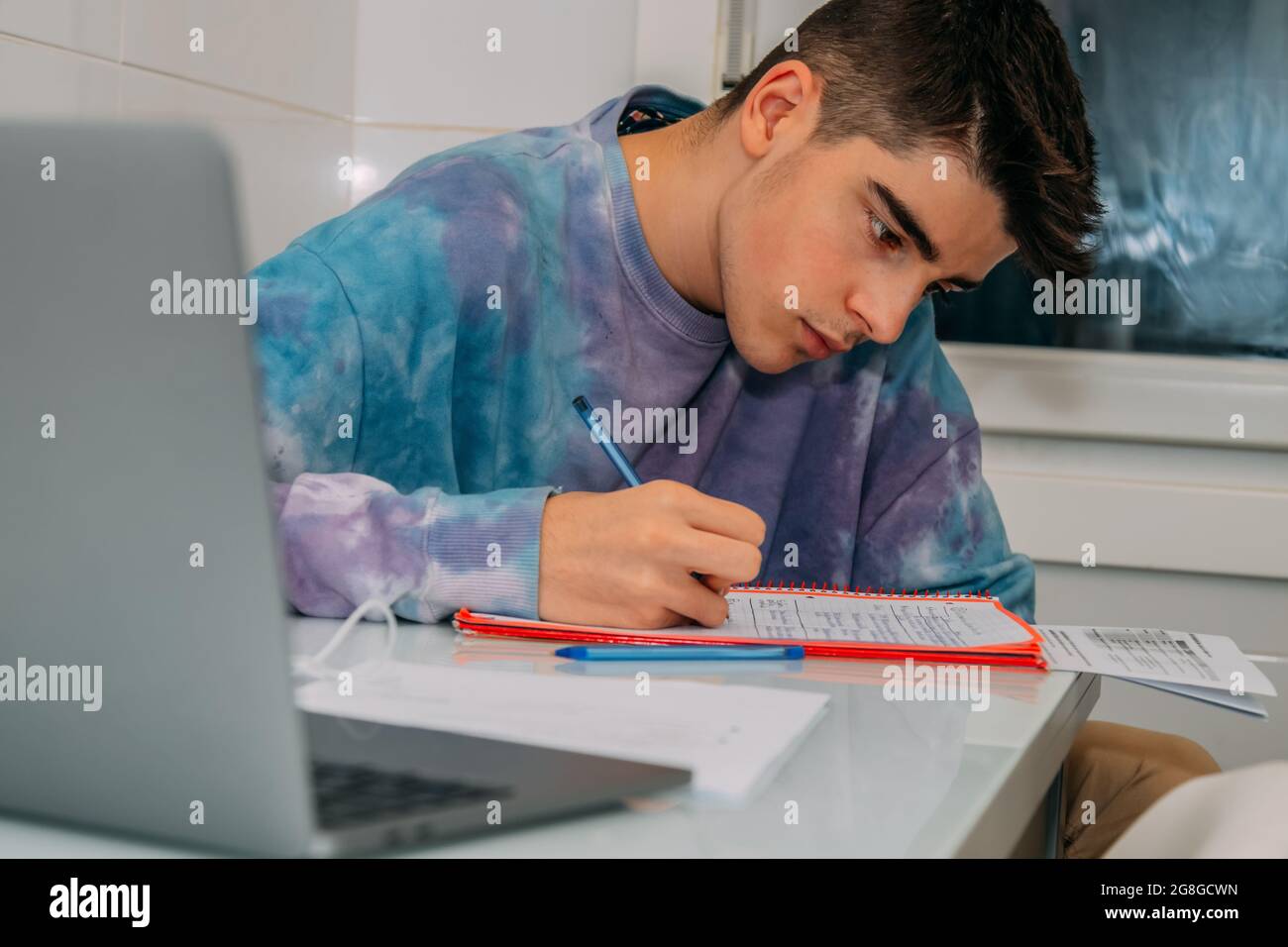 student at the table writing and studying Stock Photo - Alamy
