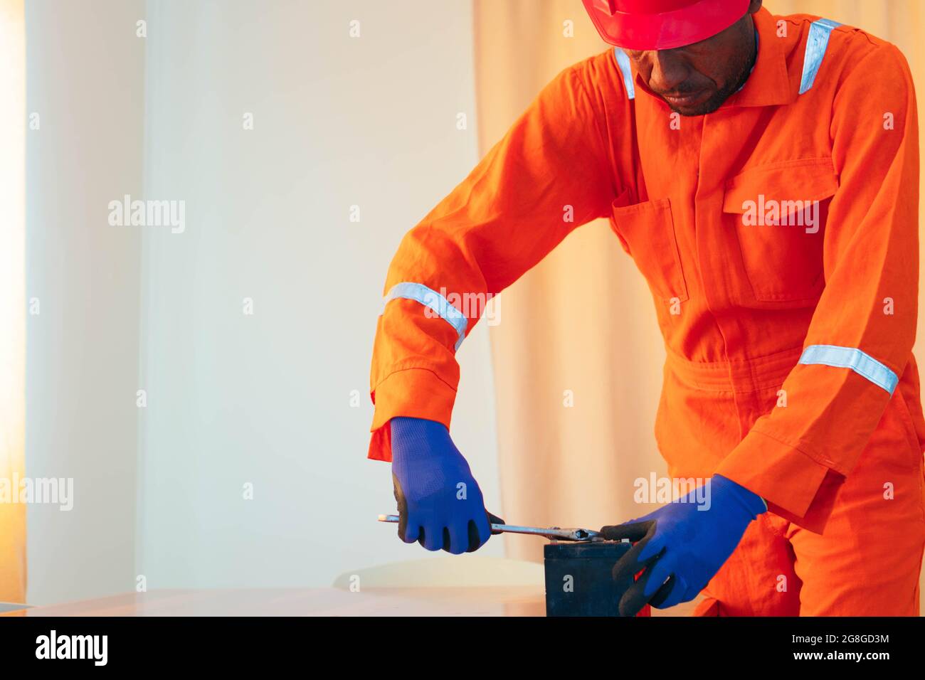 Black mechanic working on a house Stock Photo - Alamy