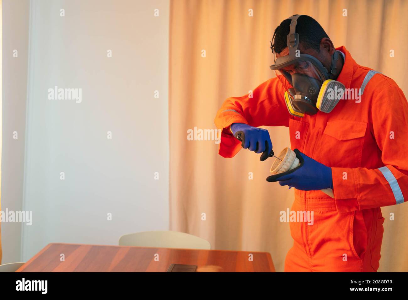Man in gas mask is repairing a pipe at home Stock Photo - Alamy