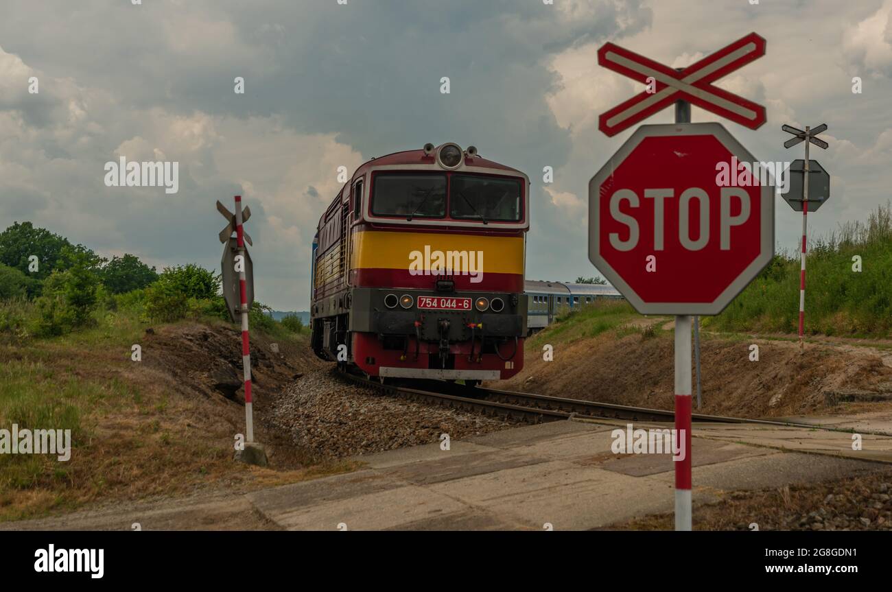 Diesel red train near Sazava river in south of Prague in summer cloudy ...