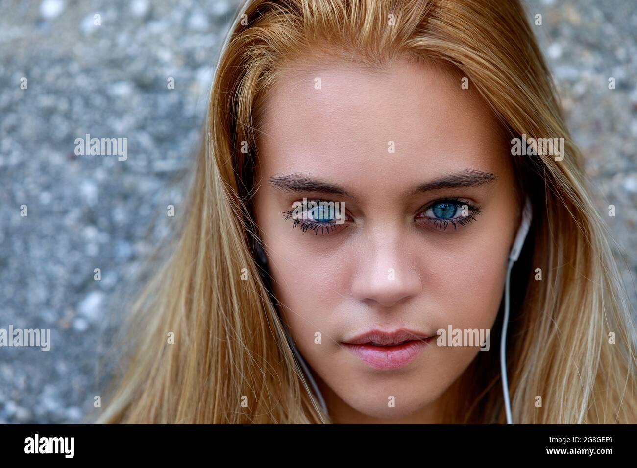 portrait of gorgeous girl staring at you while listening to music from ...