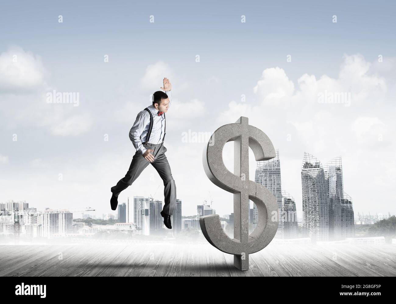 Determined banker man against modern cityscape breaking dollar concrete ...