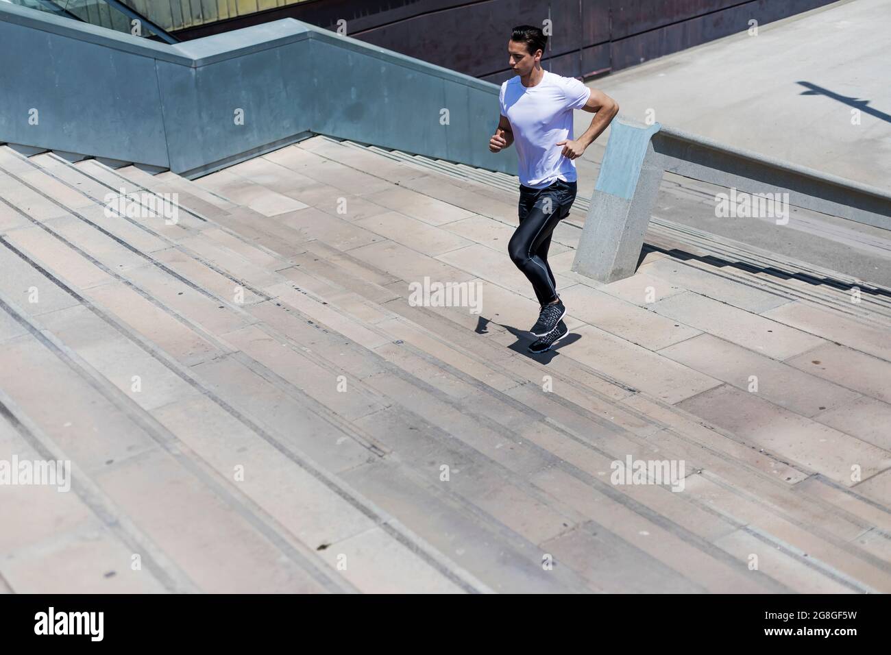 Young man running upstairs hi-res stock photography and images - Alamy