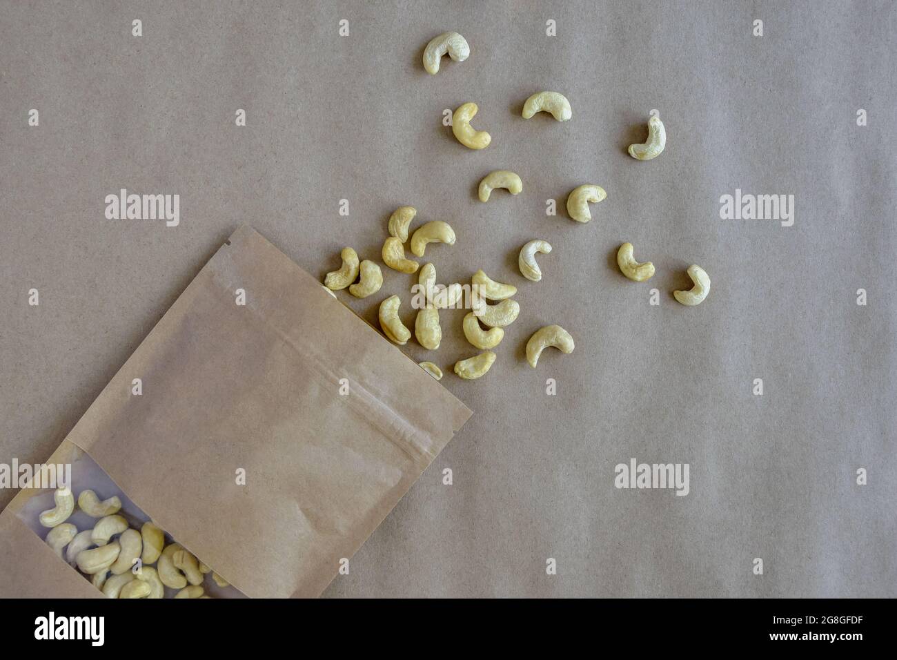 Cashew nuts in eco-friendly paper packaging and on kraft paper. Healthy ...