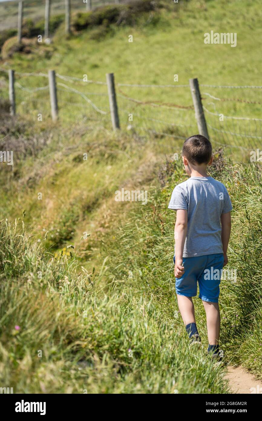 Vertical shot of a Caucasian walking in a field in the United Kingdom ...