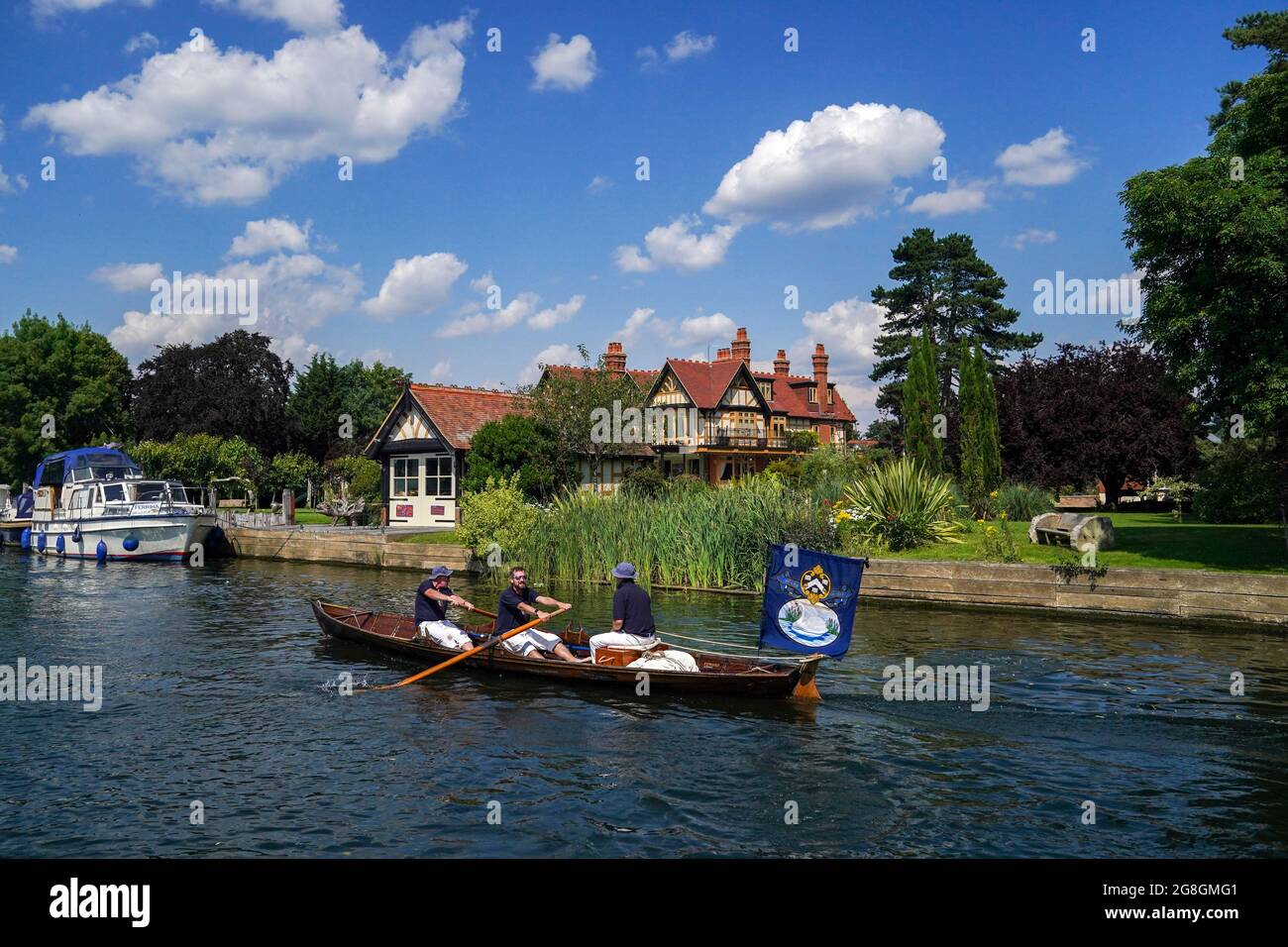 Swan Uppers trow past a house in Cookham, Berkshire, during the ancient ...