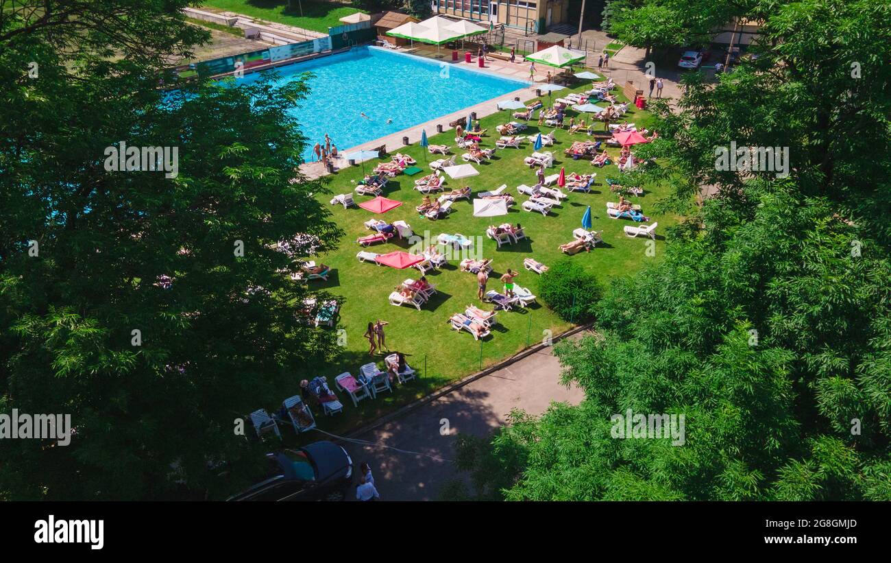 aerial view of people resting sunbathing near city pool outdoors summer ...