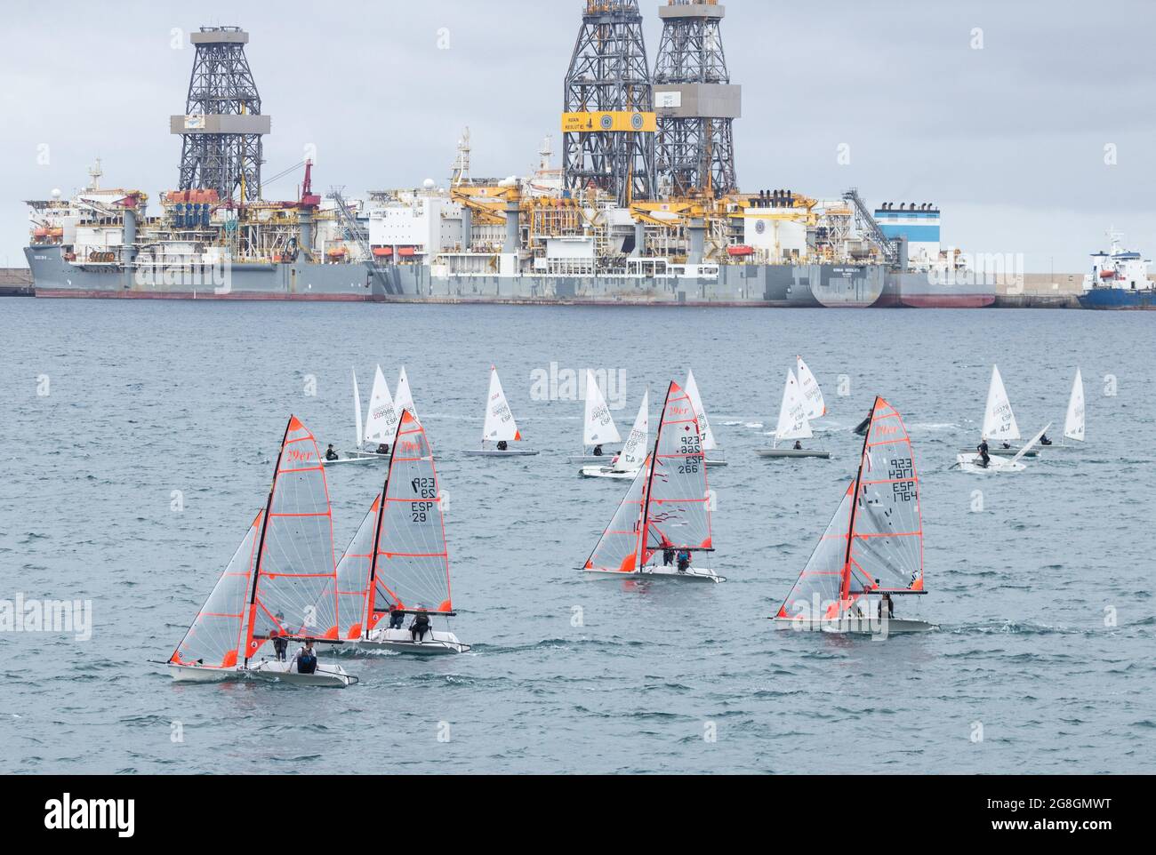 Small sailing craft near drilling ships Stock Photo - Alamy