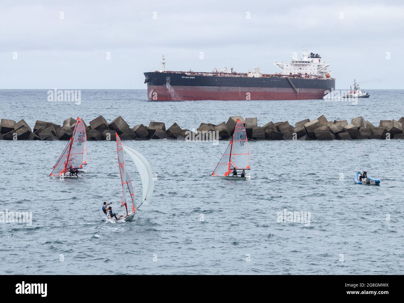 Small sailing craft near drilling ships Stock Photo - Alamy