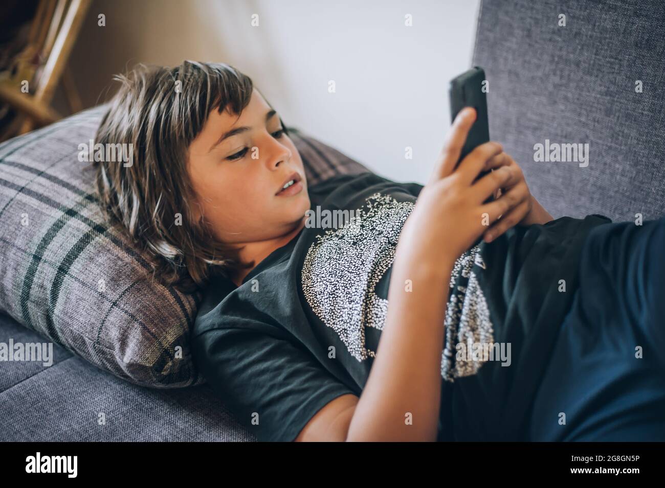 Teen boy checking social media holding smartphone, using mobile phone ...