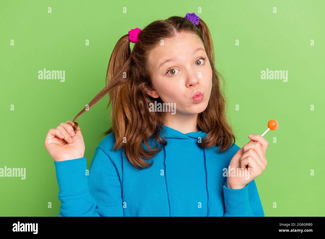 Photo of cheerful young funky happy little girl hold hand lollipop good ...
