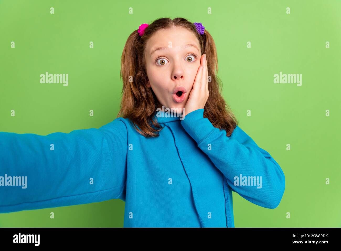 Photo of amazed shocked young little girl hold hand cheek camera make ...