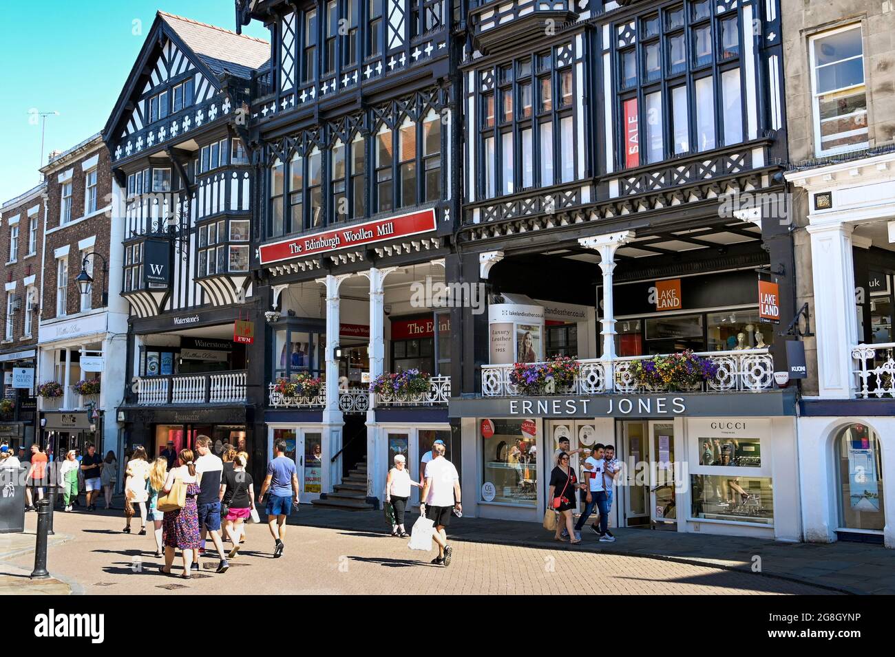 Chester, England - July 2021: People walking past shops in the black ...