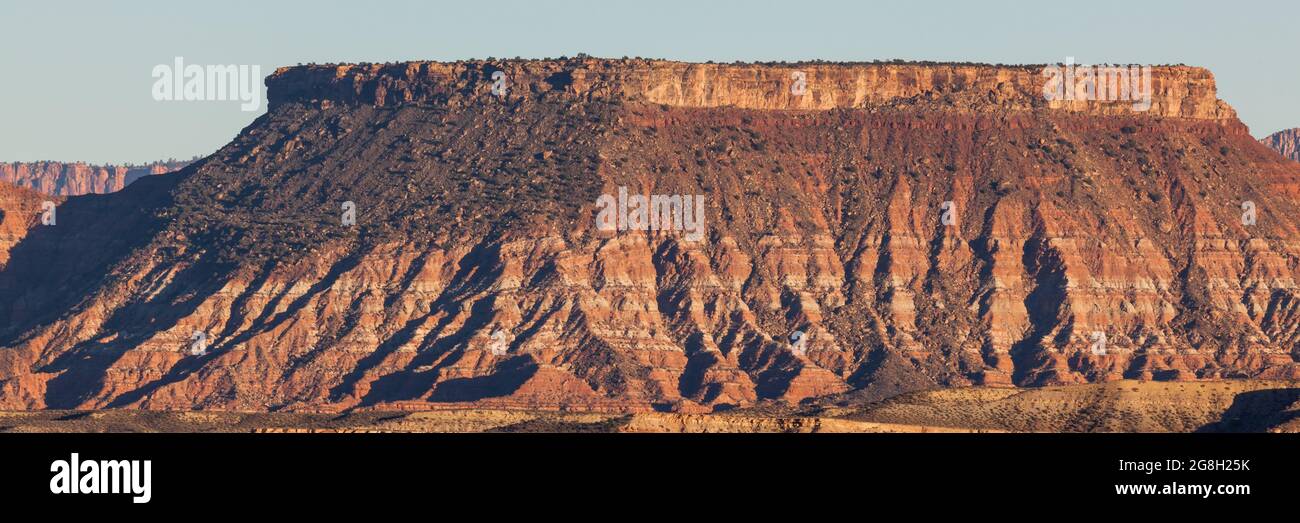 A high plateau of eroding sandstone with a dark square on the left and ...