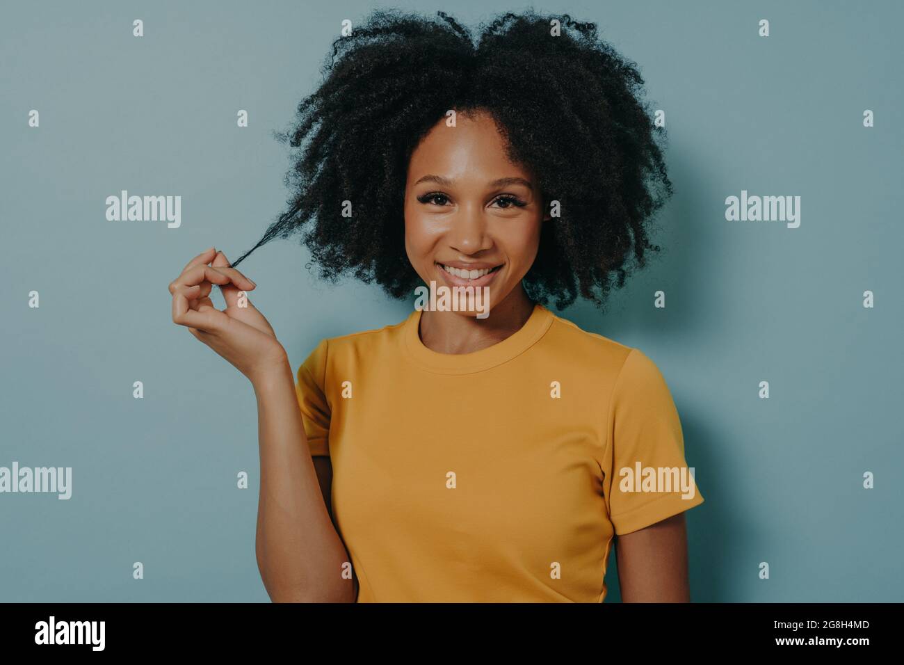 Studio portrait of beautiful young dark skinned woman with shaggy ...