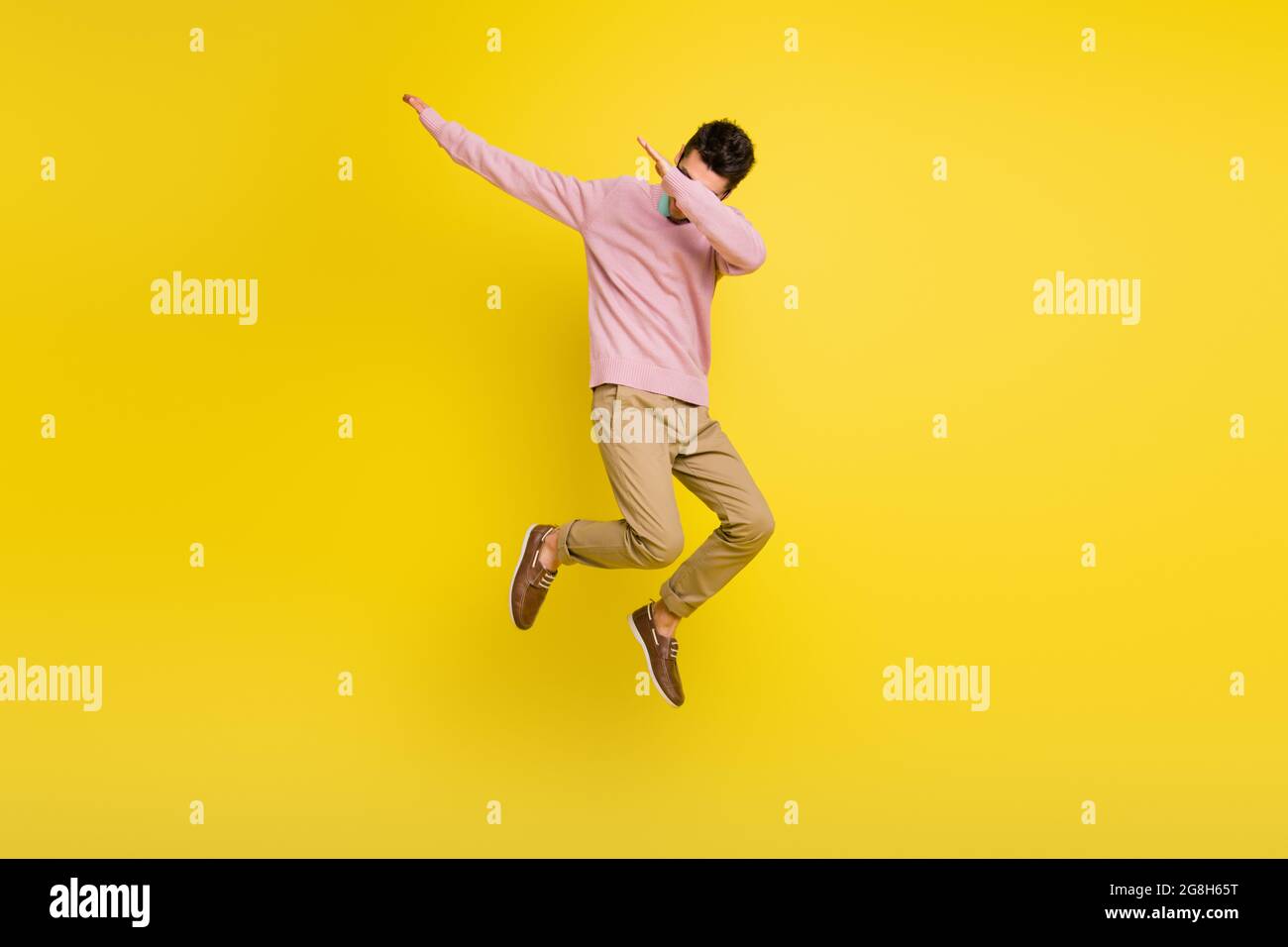 Full body photo fo young man jump up cover face hands dance active ...