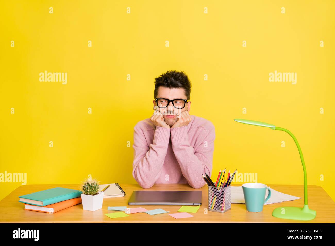 Photo of young man unhappy sad hands touch cheeks sit table bored ...