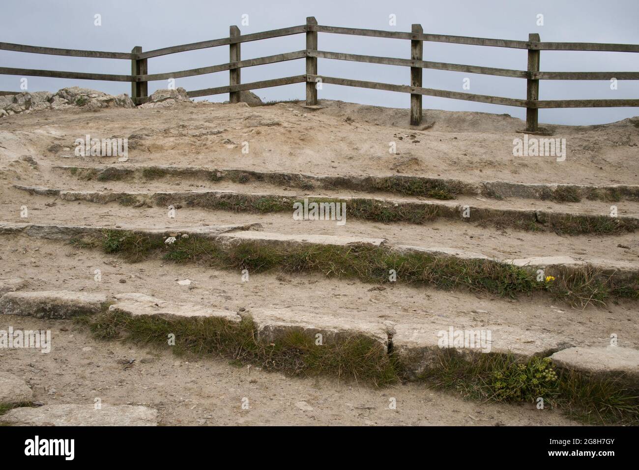Closeup of old dirty stone steps surrounded by wooden fences in a park ...