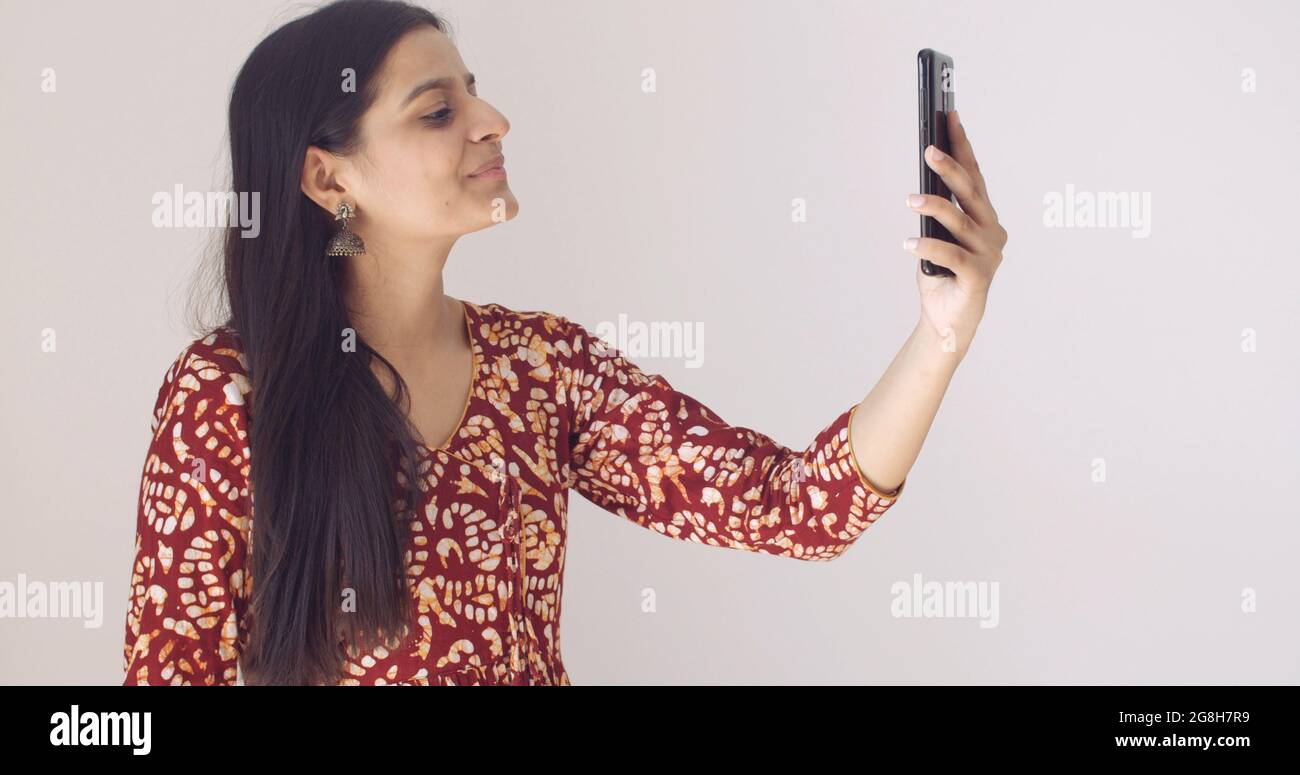 Young Indian female joining a video call isolated on background of a ...