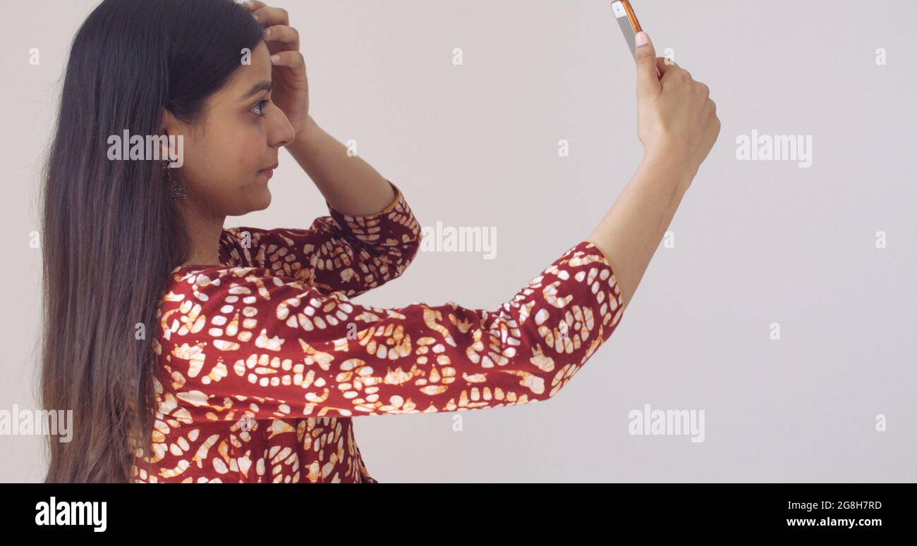 Young Indian female joining a video call isolated on background of a ...