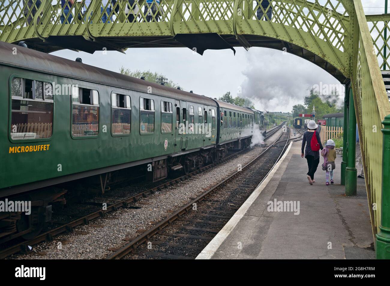 Steam train on the platform of Corfe Castle train station with ...