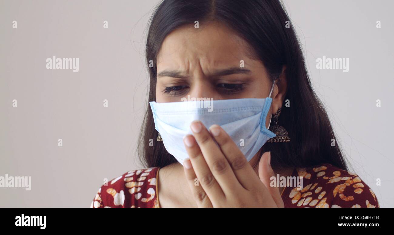 Young Indian female wearing a face mask, coughing and feeling bad Stock ...