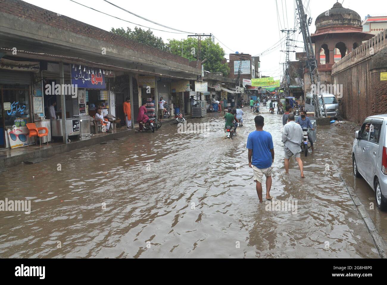 Lahore, Pakistan. 20th July, 2021. Pakistani commuters wade through a ...