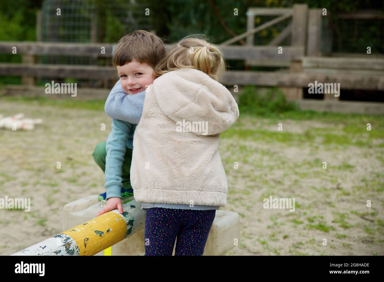 Caucasian kids hugging each other while playing outside Stock Photo - Alamy