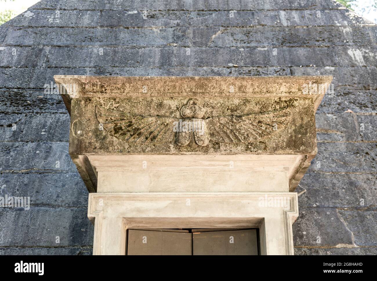 Basrelief of an insect onan old pyramid-shape ice house, building used ...