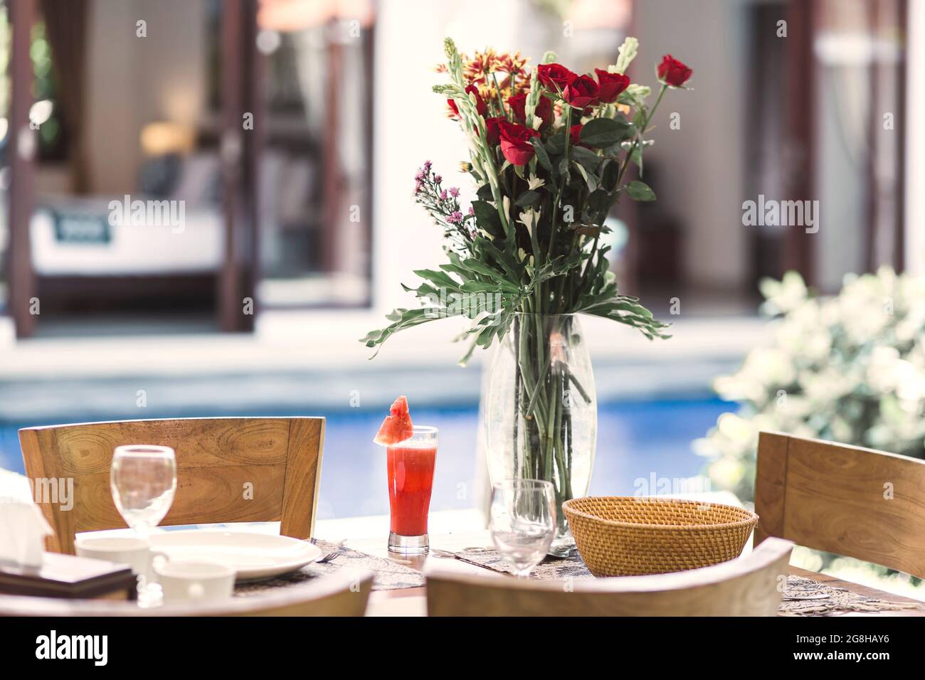 Flower bouquet at the table and pool in background Stock Photo - Alamy