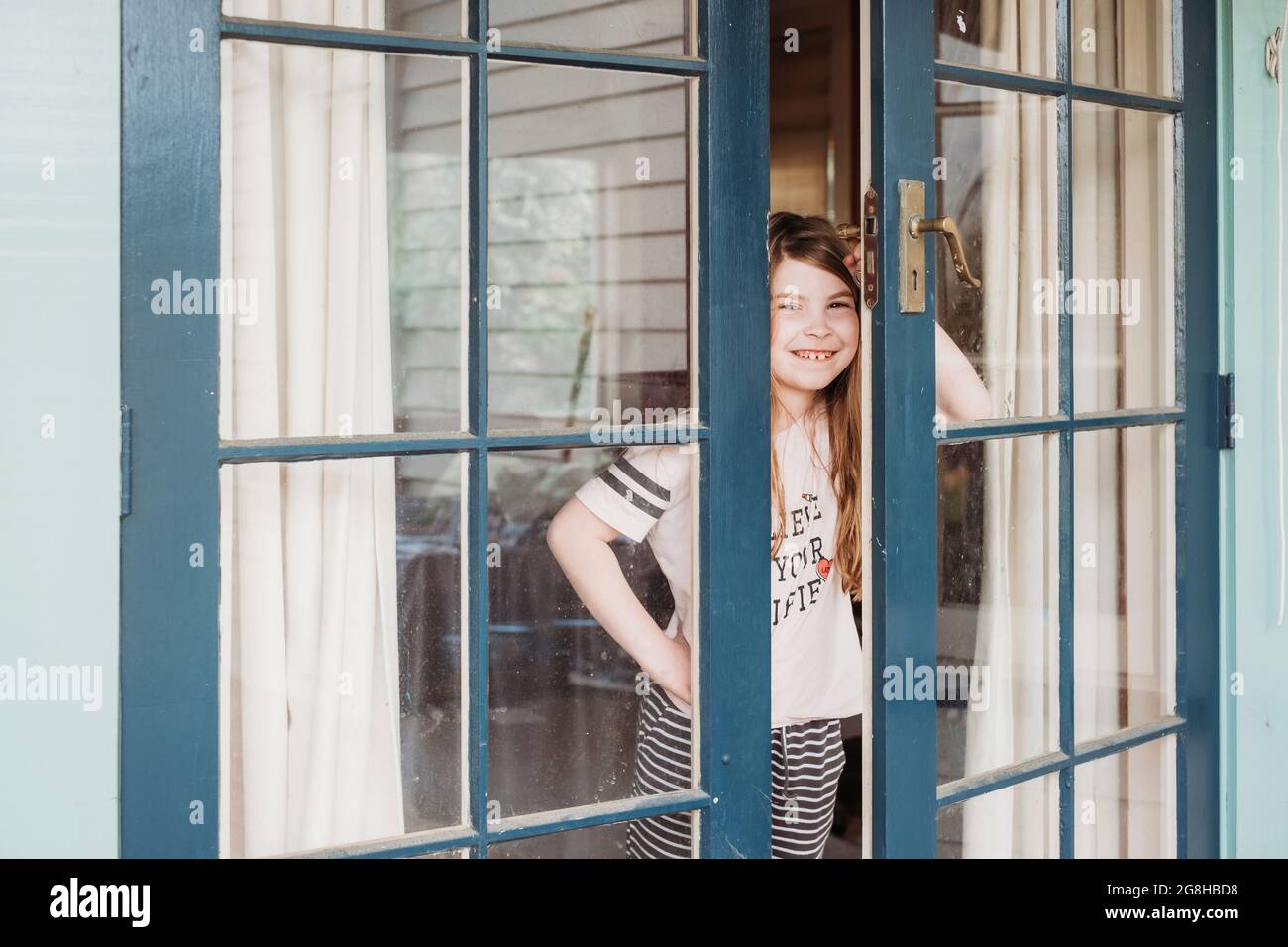 Girl smiling and opening outside door Stock Photo - Alamy