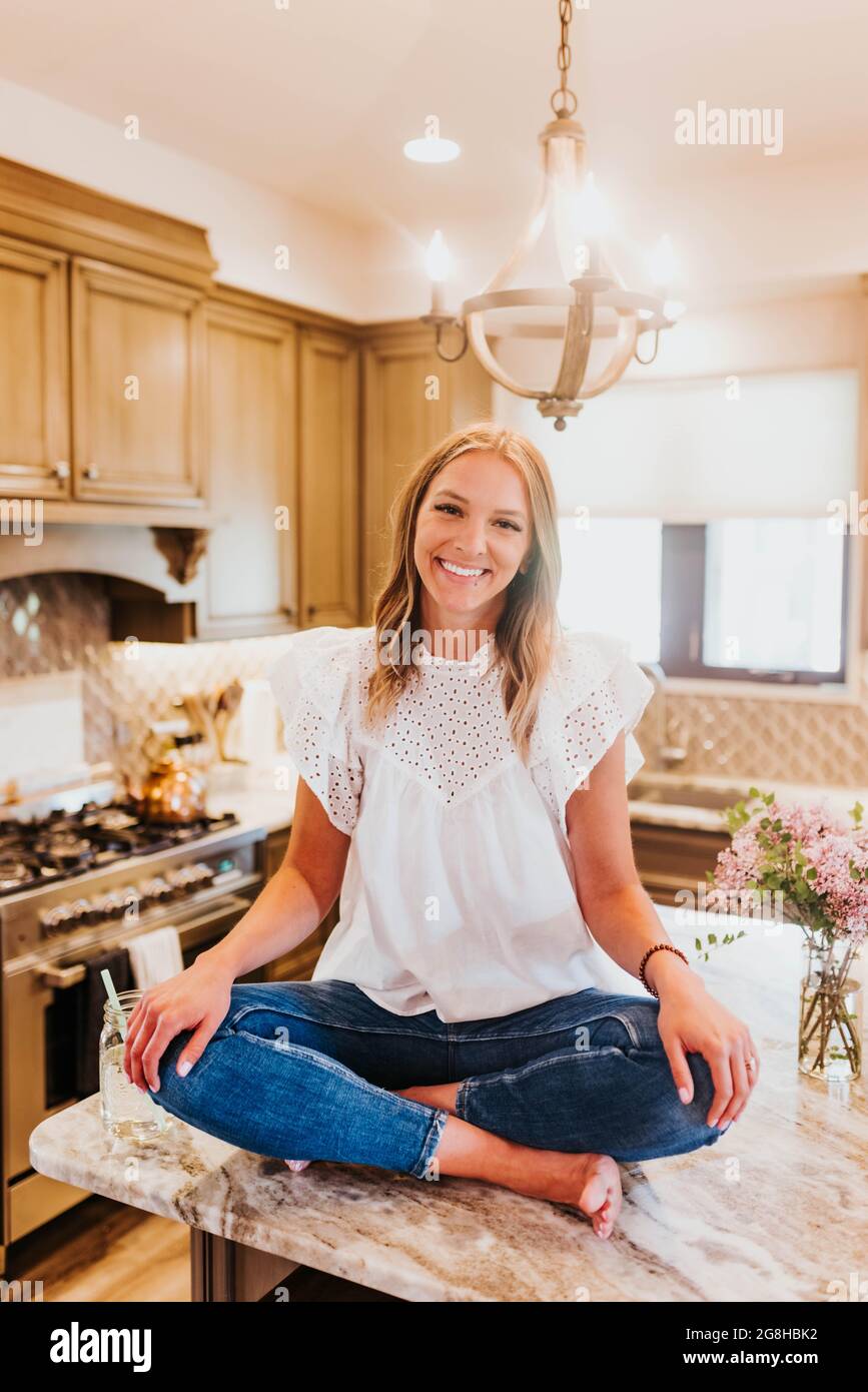 Woman sitting on kitchen counter hi-res stock photography and images ...