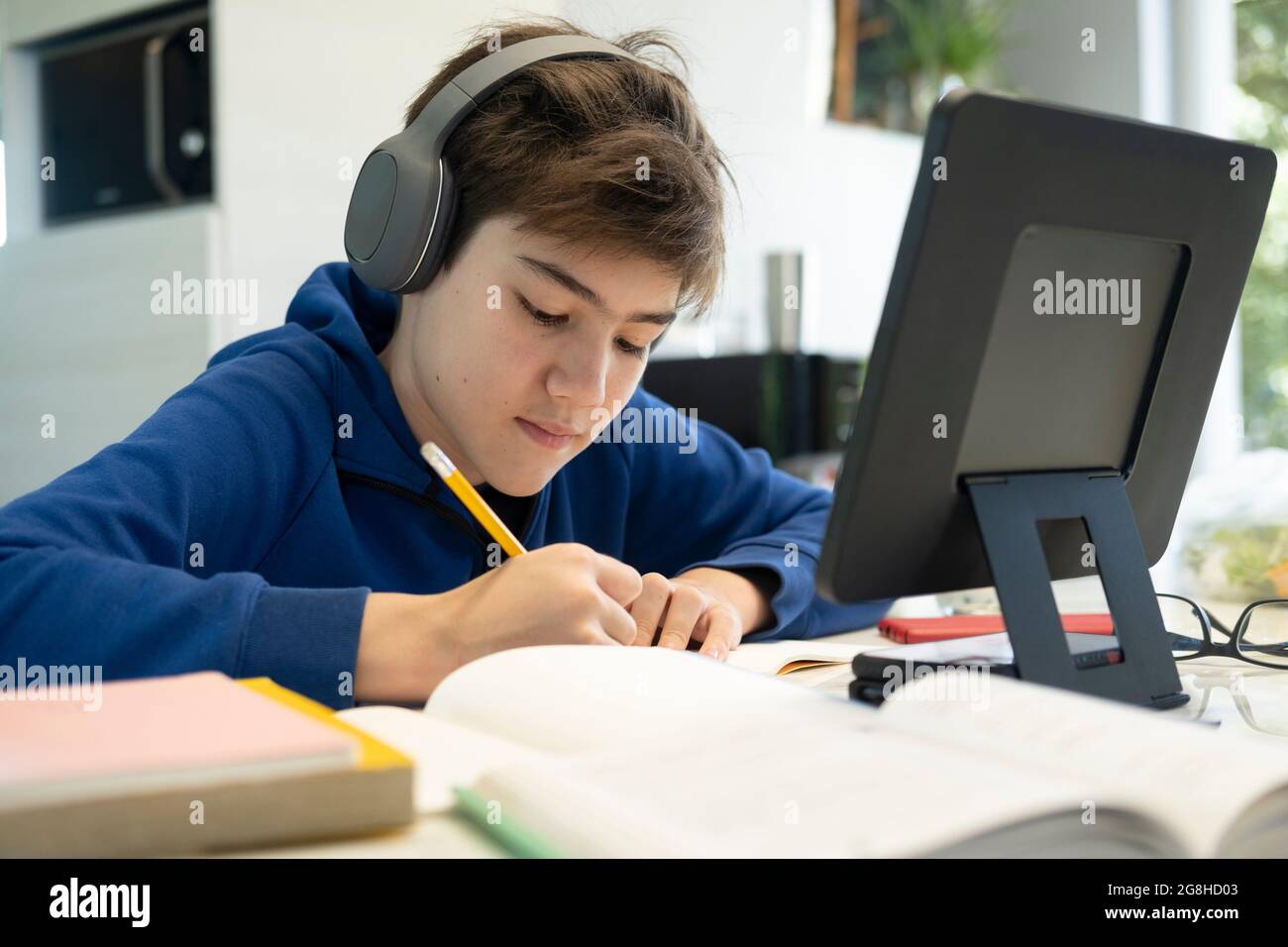 Young collage student using computer and mobile device studying online ...