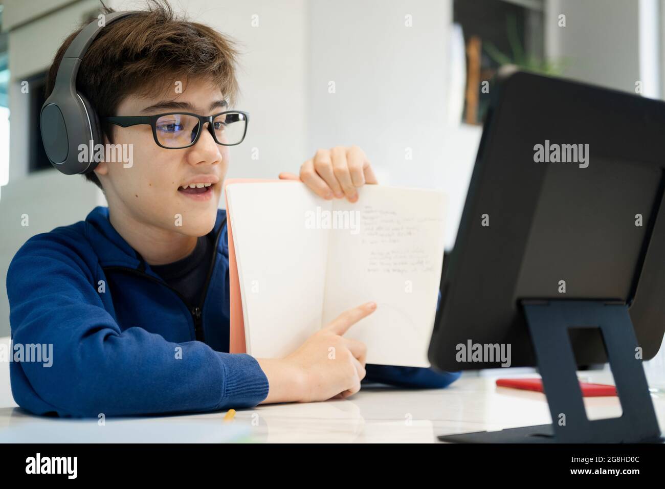 Young collage student using computer and mobile device studying online ...