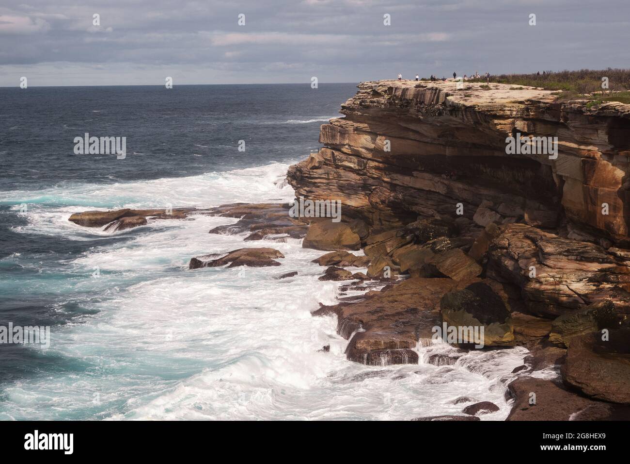 Landscape of rocky cliffs surrounded by the sea under a cloudy sky in ...