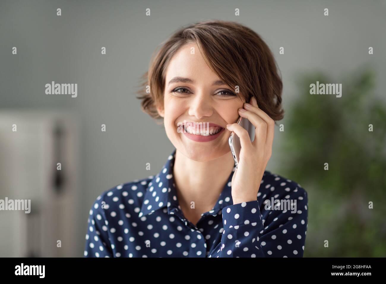 Close-up portrait of attractive cheerful brown-haired girl calling ...