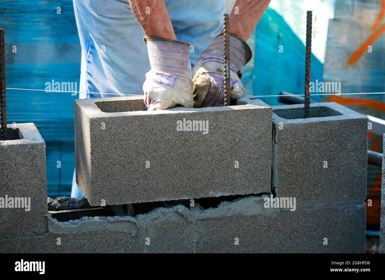 Construction site: building wall of concrete block. Mason is laying ...