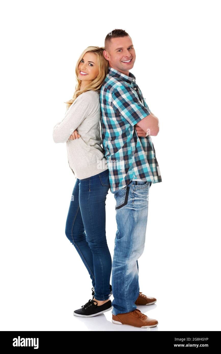 Happy Caucasian couple leaning on each other's backs on a white ...